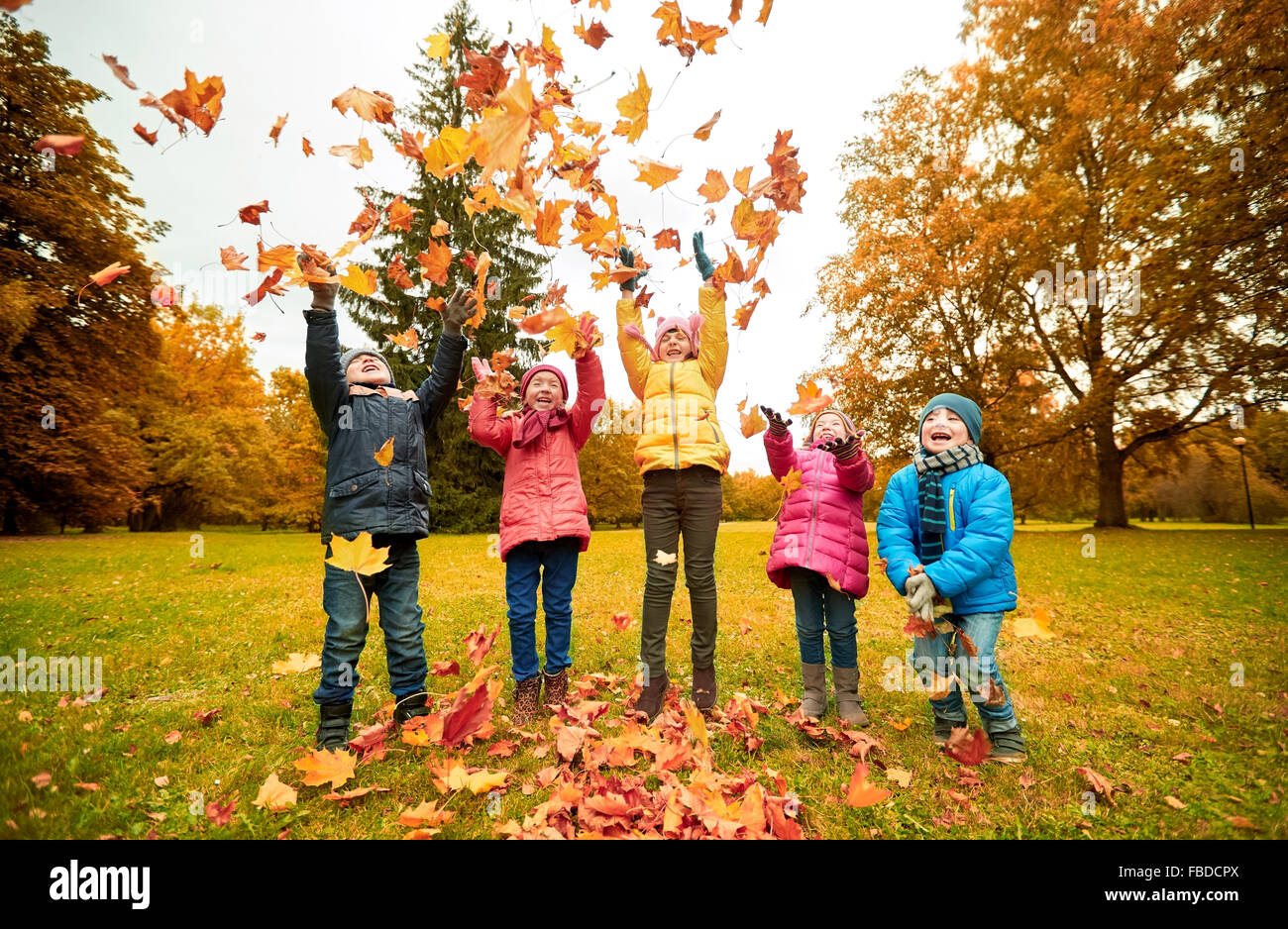 happy children playing with autumn leaves in park Stock Photo - Alamy