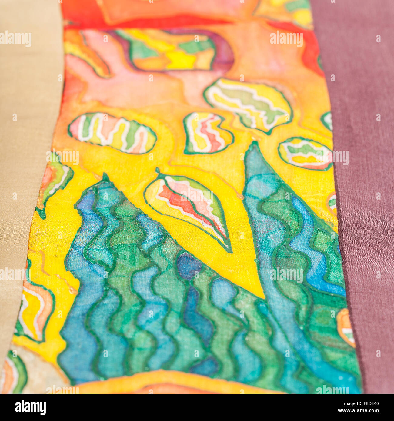 textile background - strip of patchwork cloth with painted silk batik ...