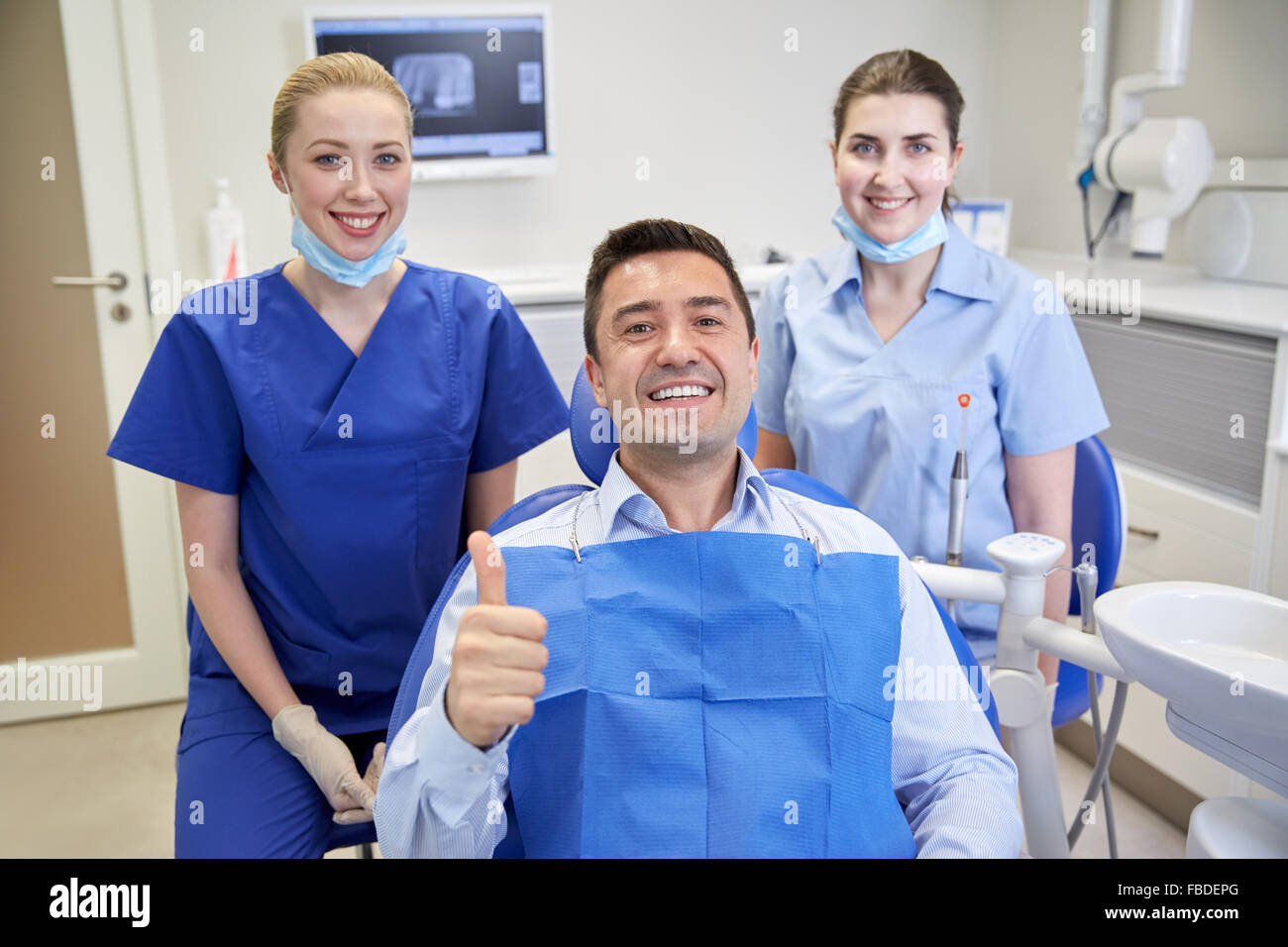 happy female dentists with man patient at clinic Stock Photo - Alamy