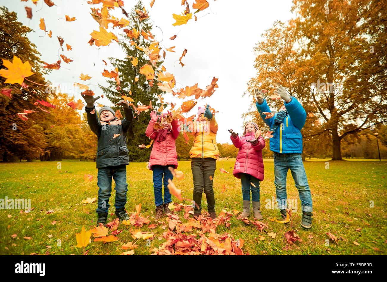 happy children playing with autumn leaves in park Stock Photo - Alamy