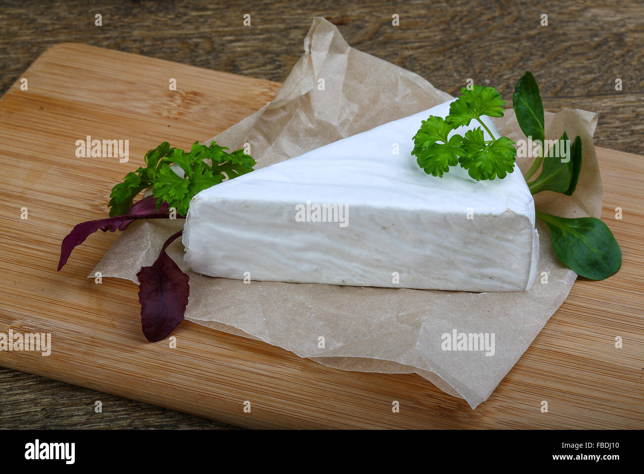 Soft brie cheese served parsley leaves on wooden background Stock Photo ...