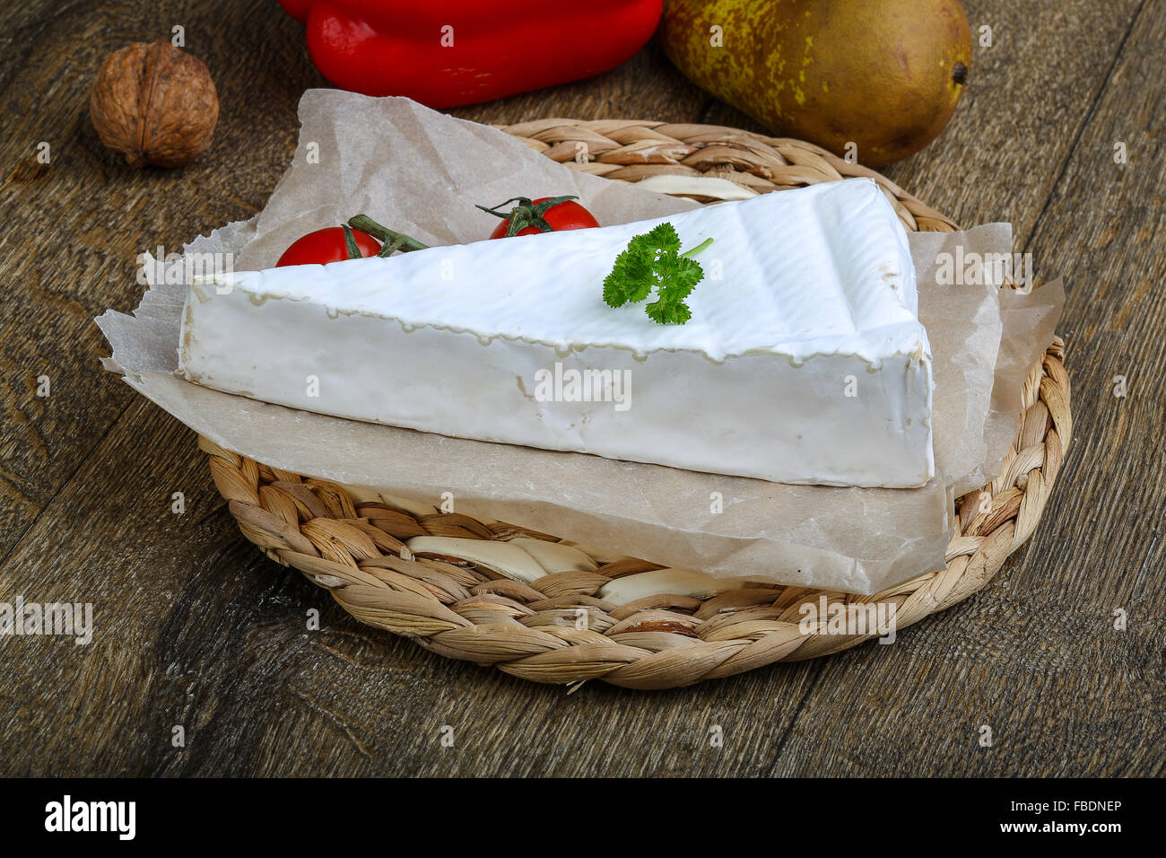Brie cheese triangle with tomato and parsley Stock Photo - Alamy