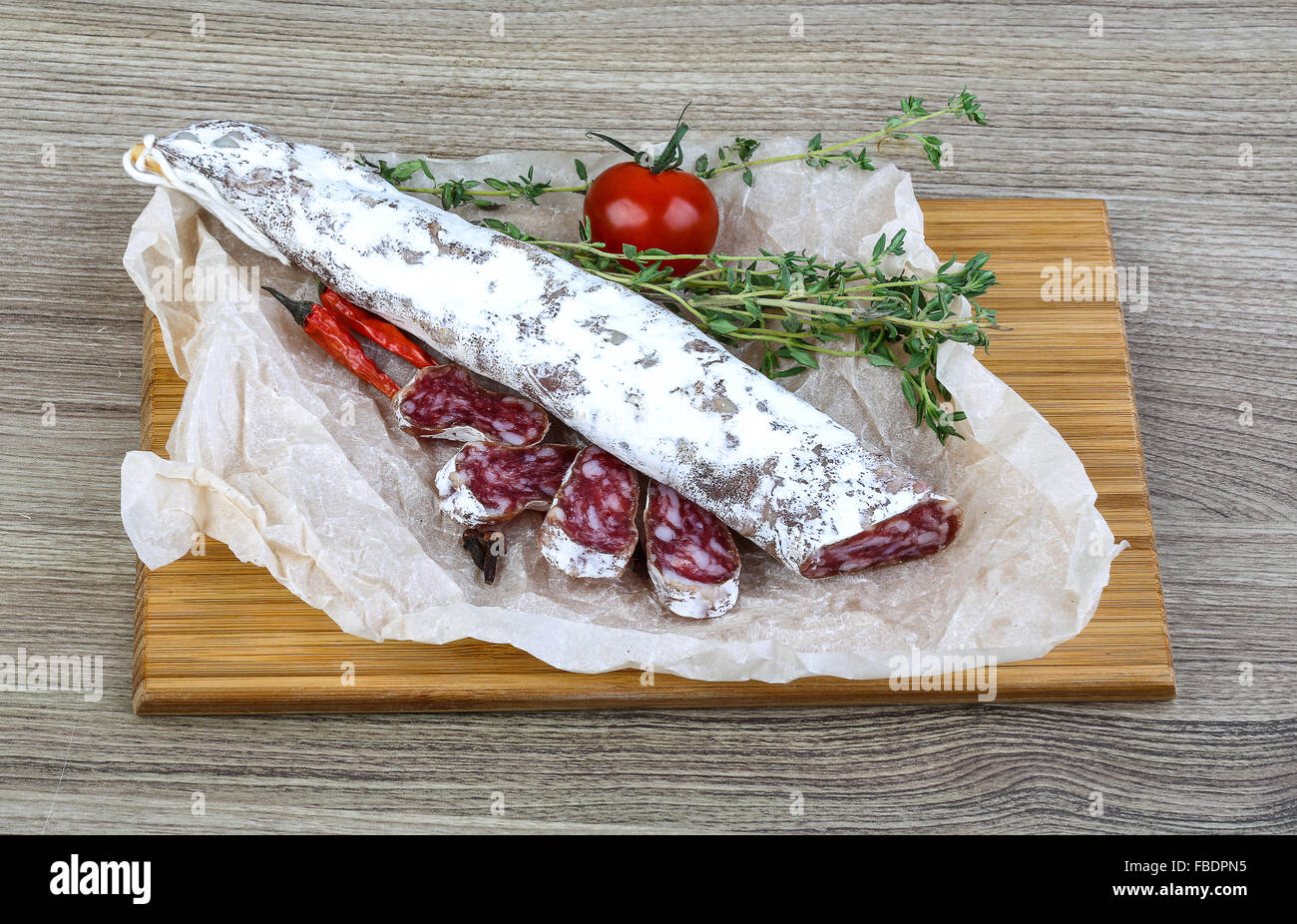 Traditional Spanish sausages- fuet with thyme leaves on the wood ...