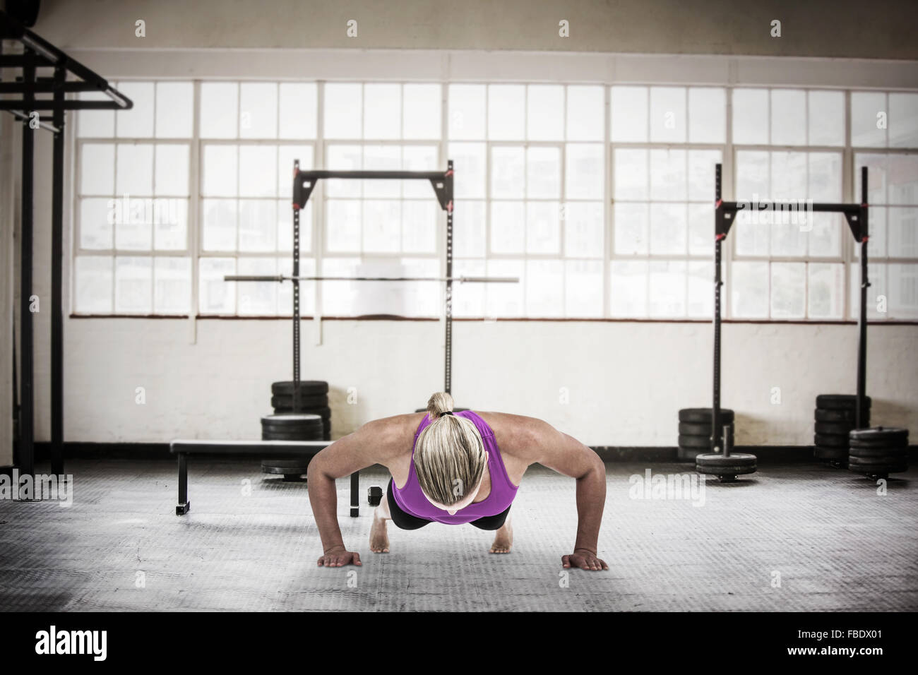Composite image of muscular woman doing push ups Stock Photo - Alamy