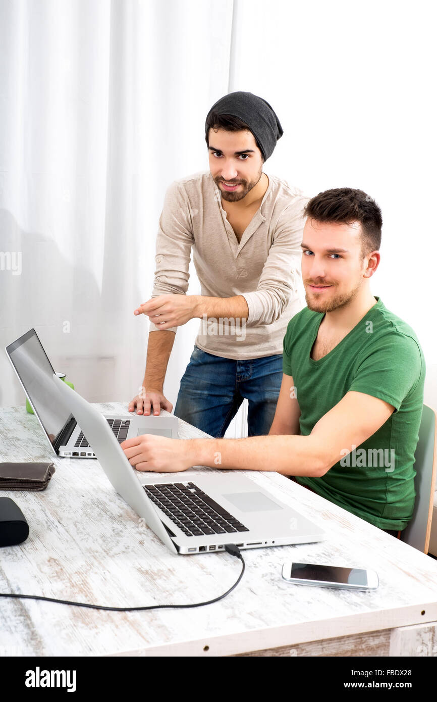 Two young colleagues discussing something in the office Stock Photo - Alamy