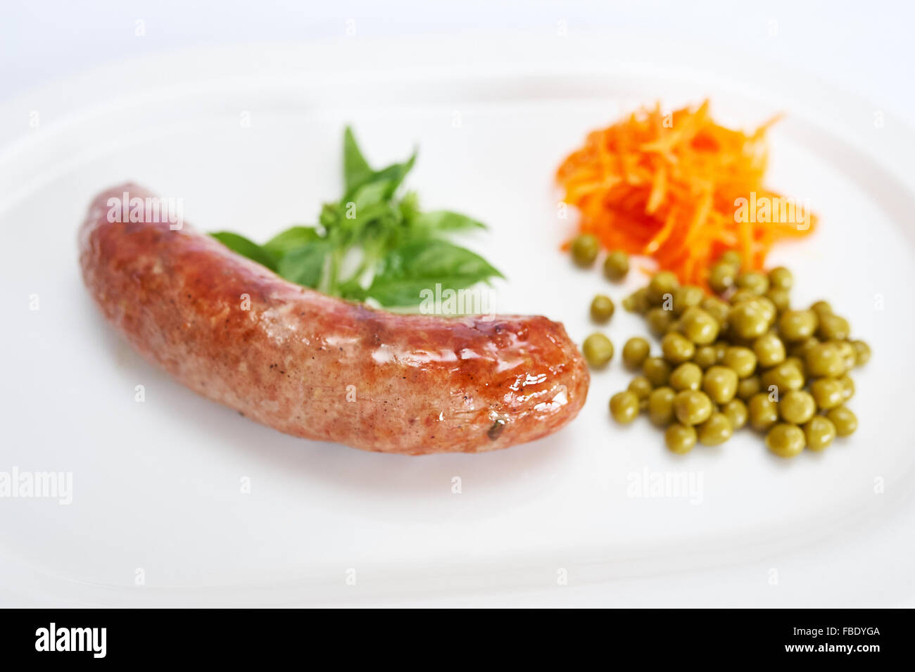 Grilled sausage with vegetables on white plate studio shot Stock Photo ...