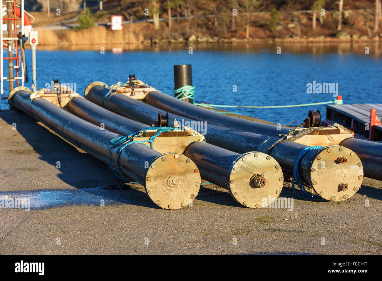 Sea cable housing tubes on the dockside in a coastal bay waiting to be ...