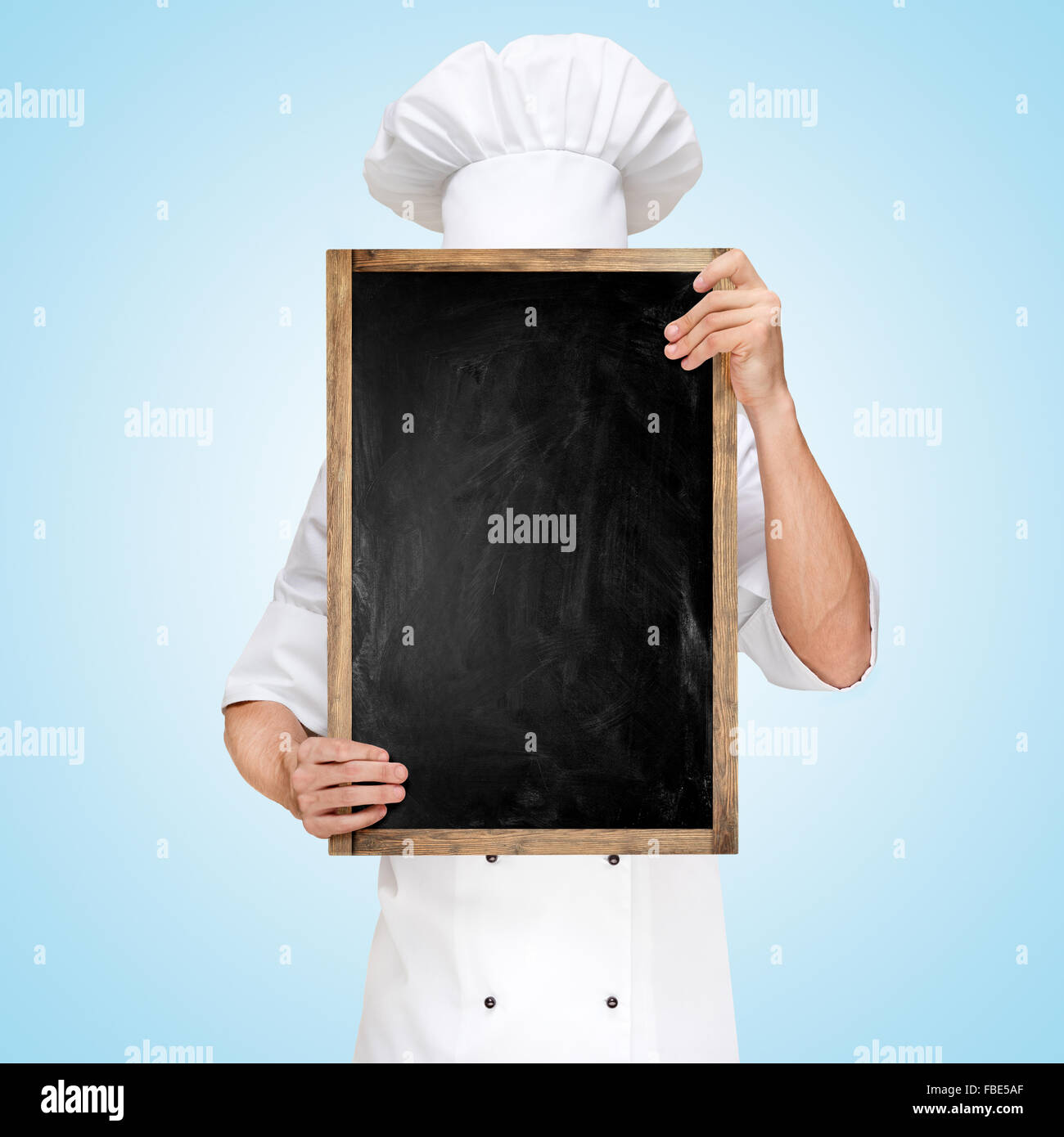 Restaurant chef hiding behind a blank chalkboard for a business lunch ...