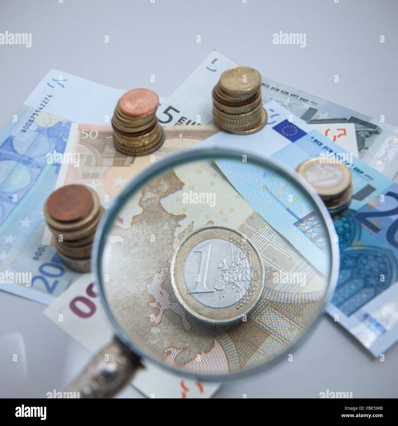 Money and magnifying glass Stock Photo - Alamy