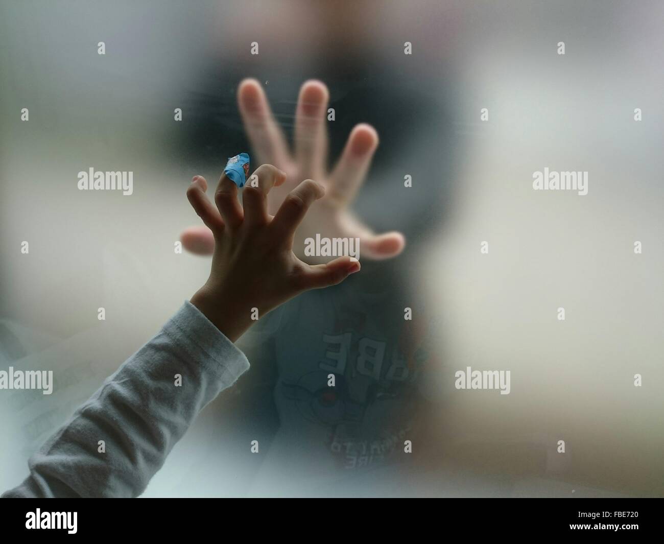 Two people touching through glass hi-res stock photography and images ...