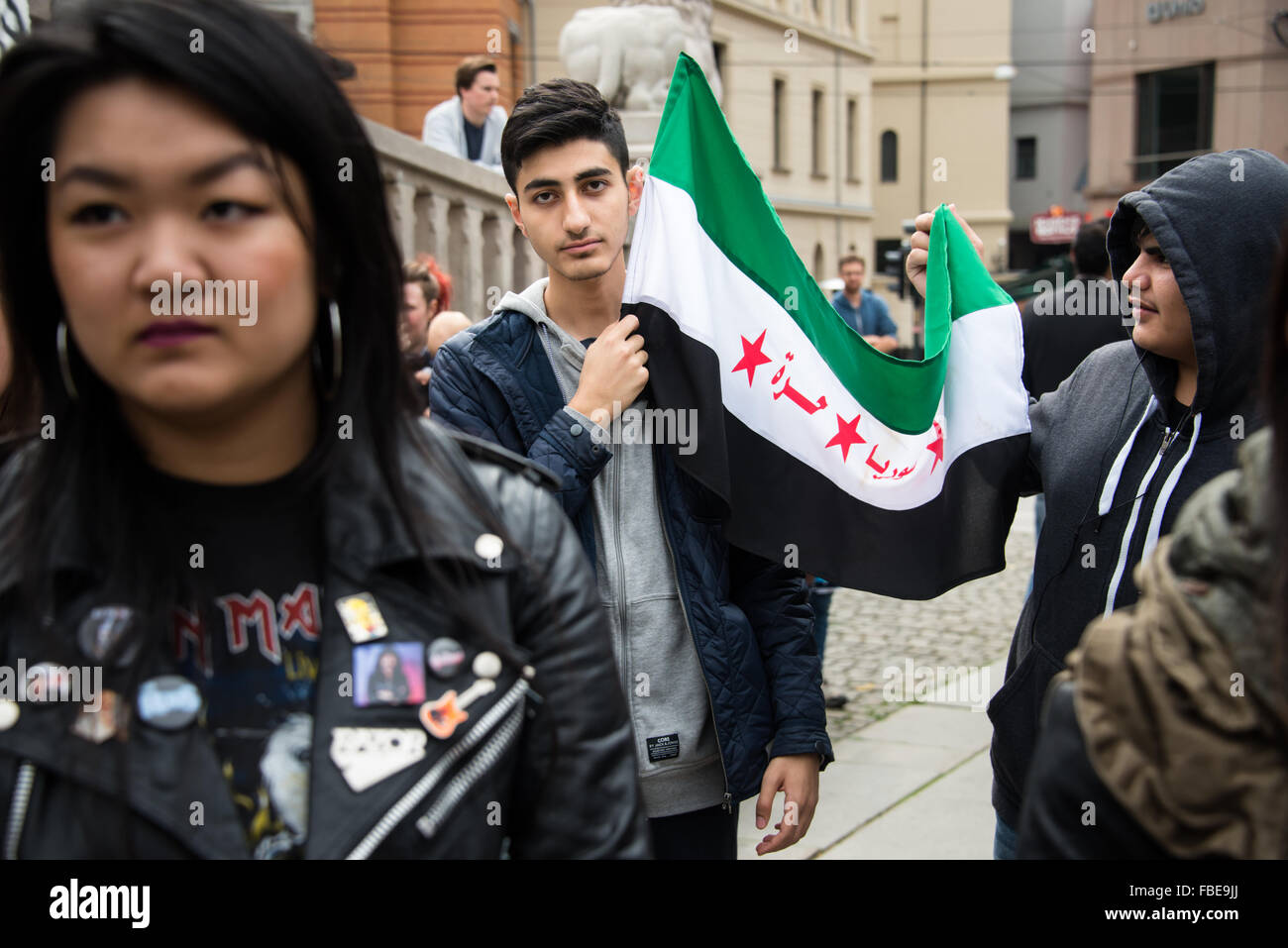 Young men hold a Syrian flag at a rally in support of Syrian refugees ...