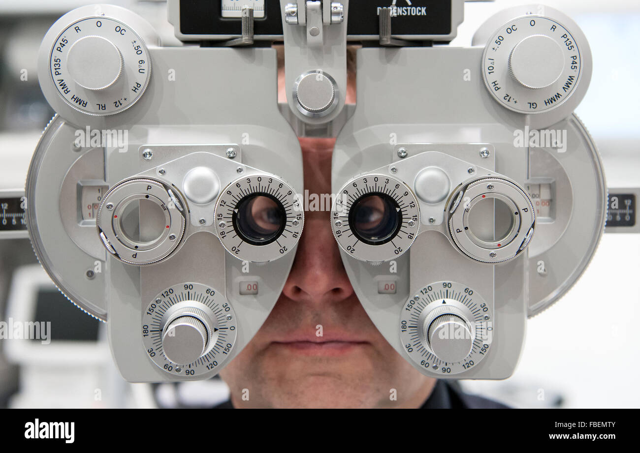 A man sits behind a phoropter at the 'Opti' international trade show ...