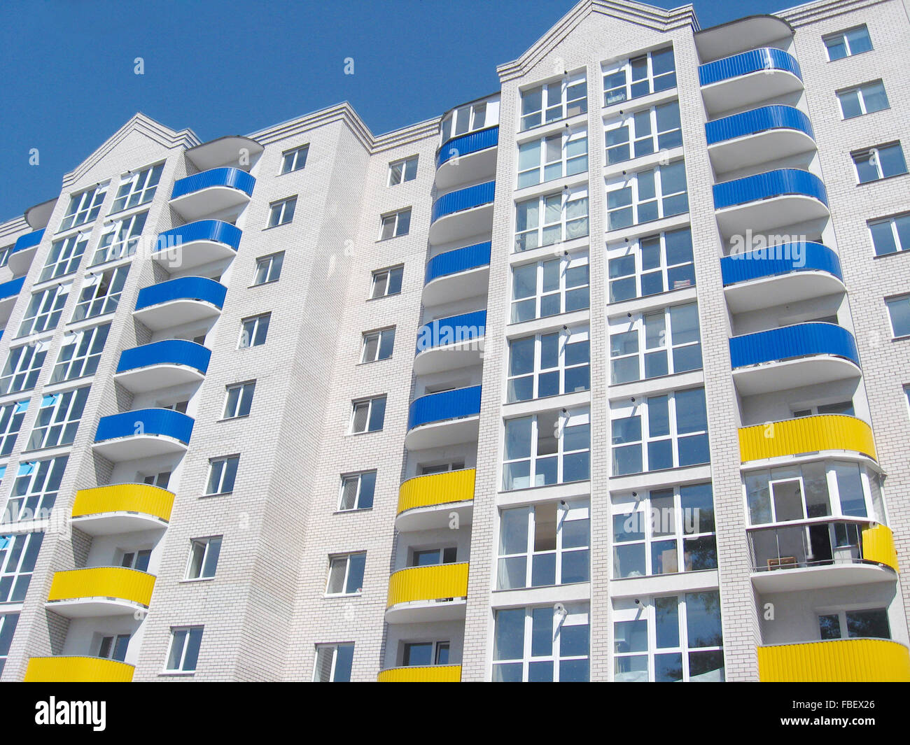 modern skyscraper in blue and yellow colors on the blue sky background ...