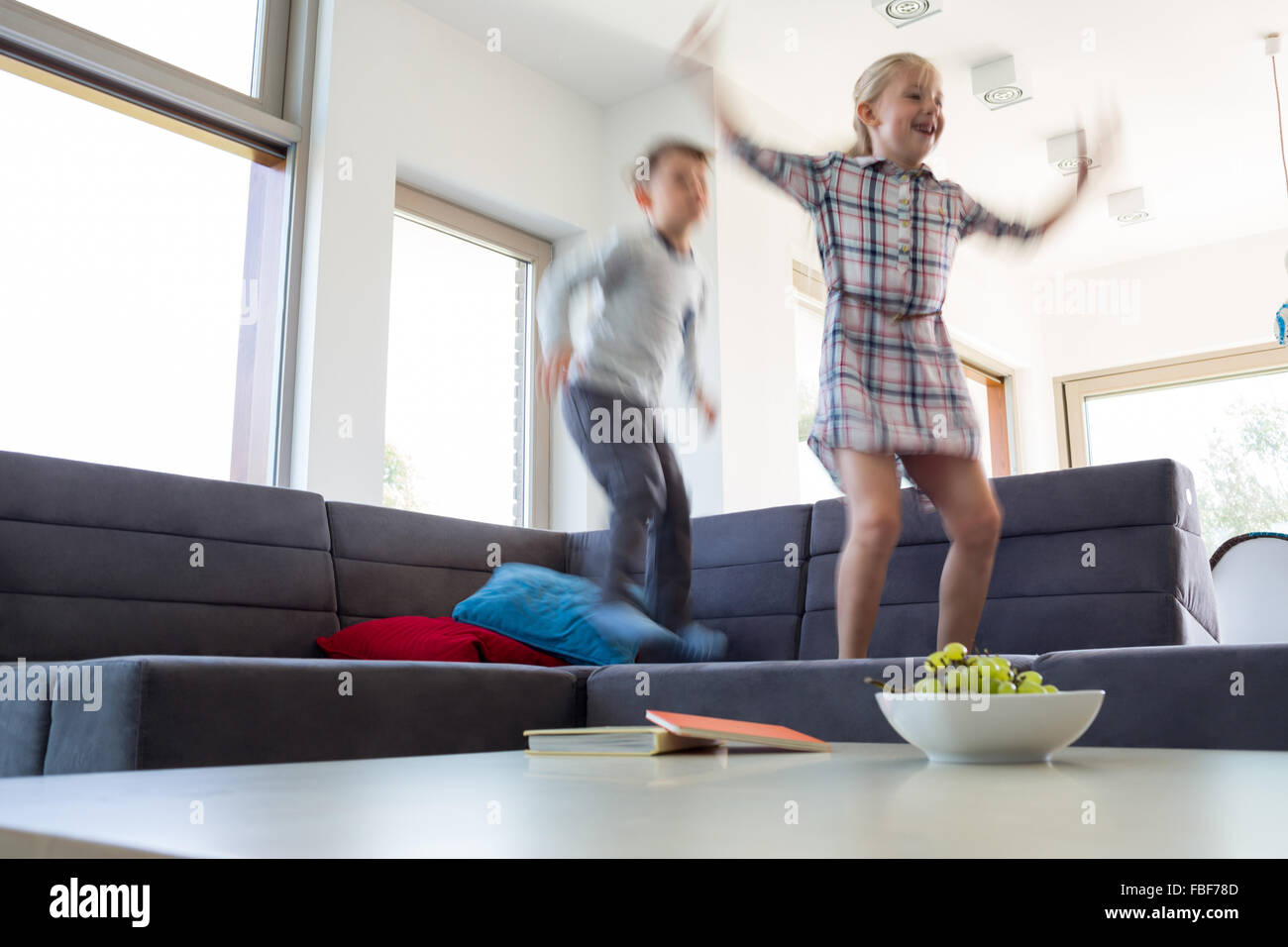 Happy child jumping on sofa hi-res stock photography and images - Alamy