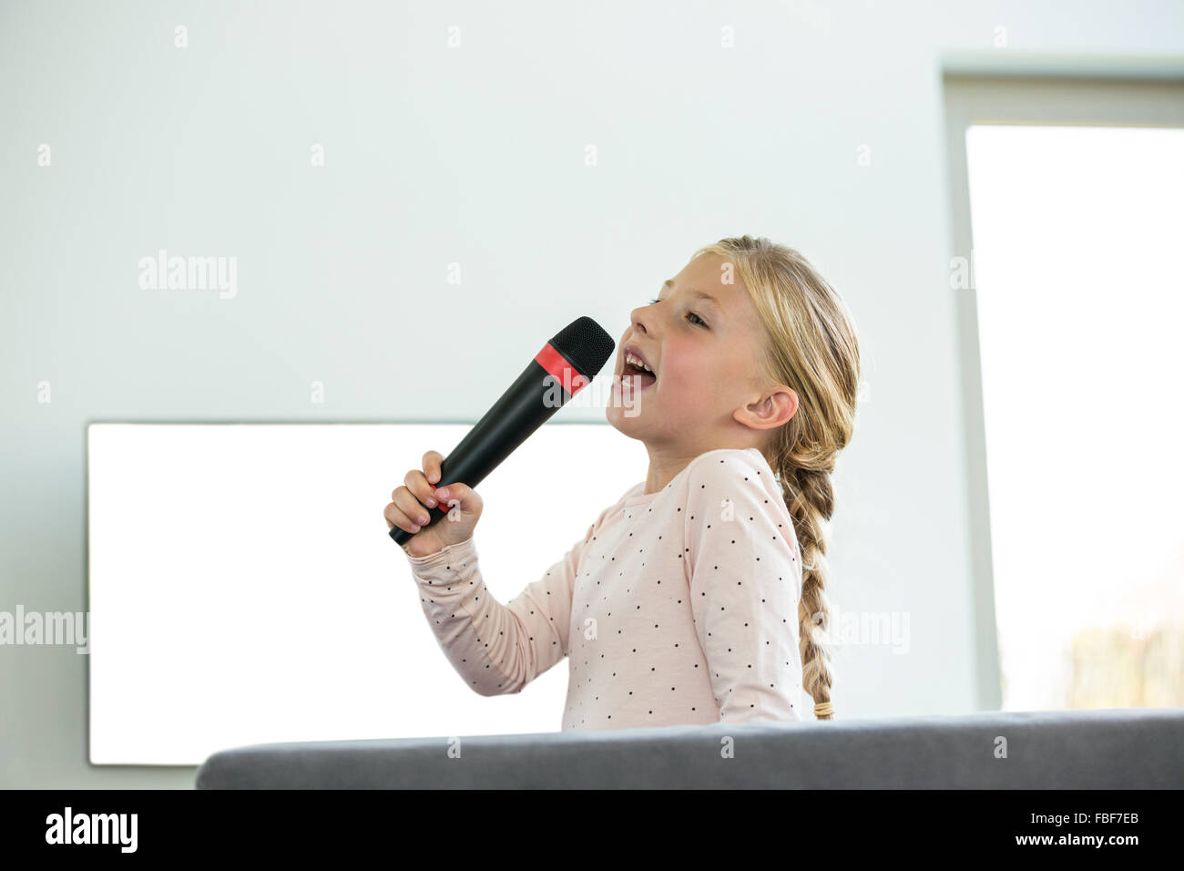 Cute girl doing karaoke Stock Photo - Alamy