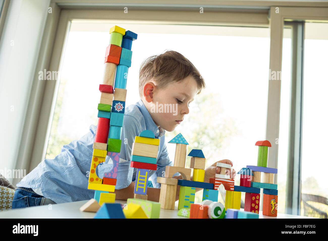 Cute boy playing with building blocks Stock Photo - Alamy