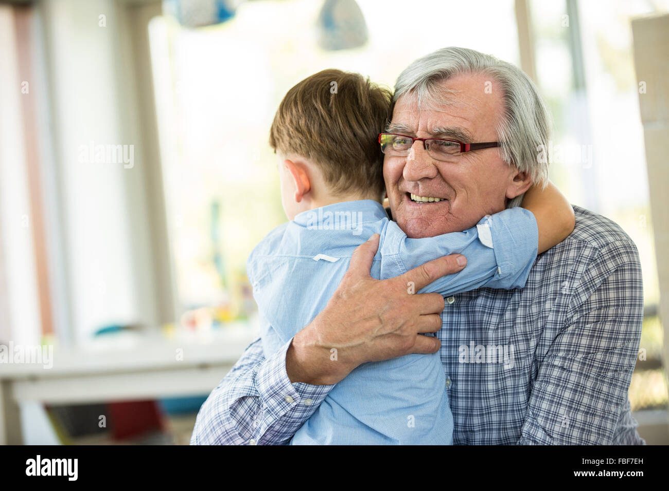 Grandson hugging grandfather Stock Photo - Alamy