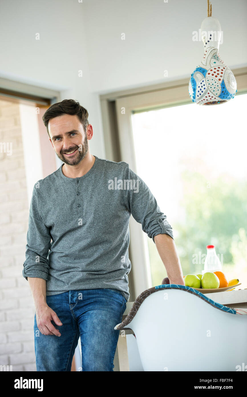 Man sitting on kitchen table Stock Photo - Alamy