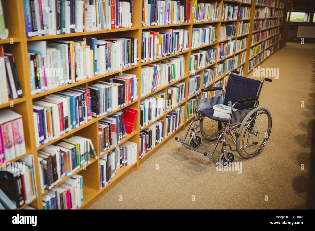 Wheelchair with books in bookshelves Stock Photo - Alamy