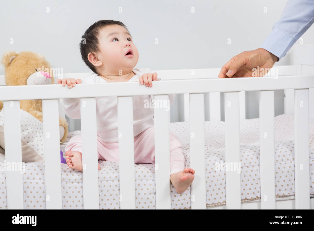 Cute baby looking up from crib Stock Photo - Alamy