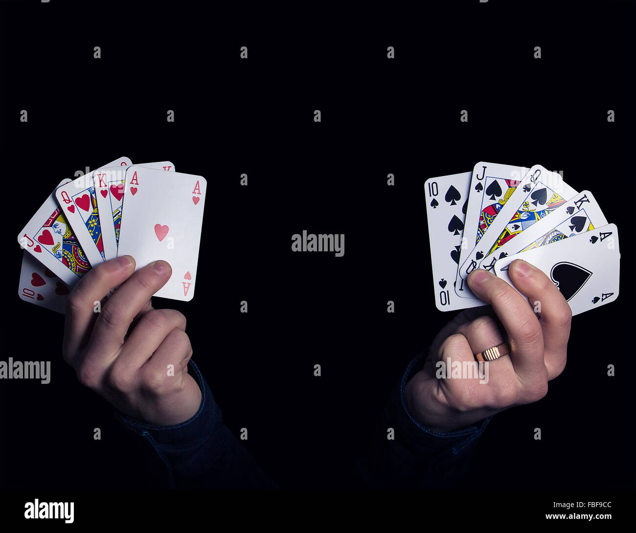 Caucasian male hands holding two royal flush poker combination of heart ...