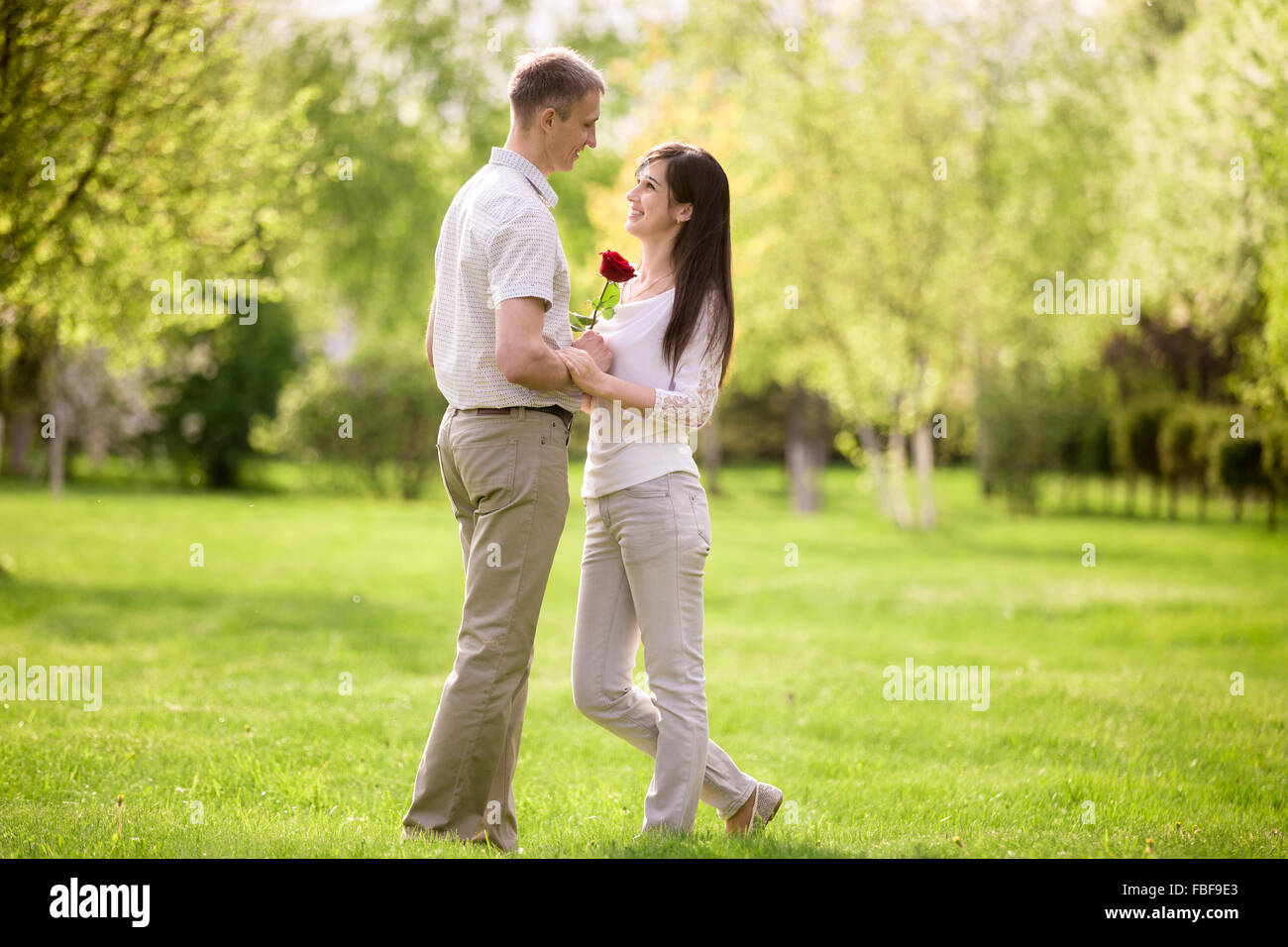 Full length portrait of young man and woman on date, meeting in park ...