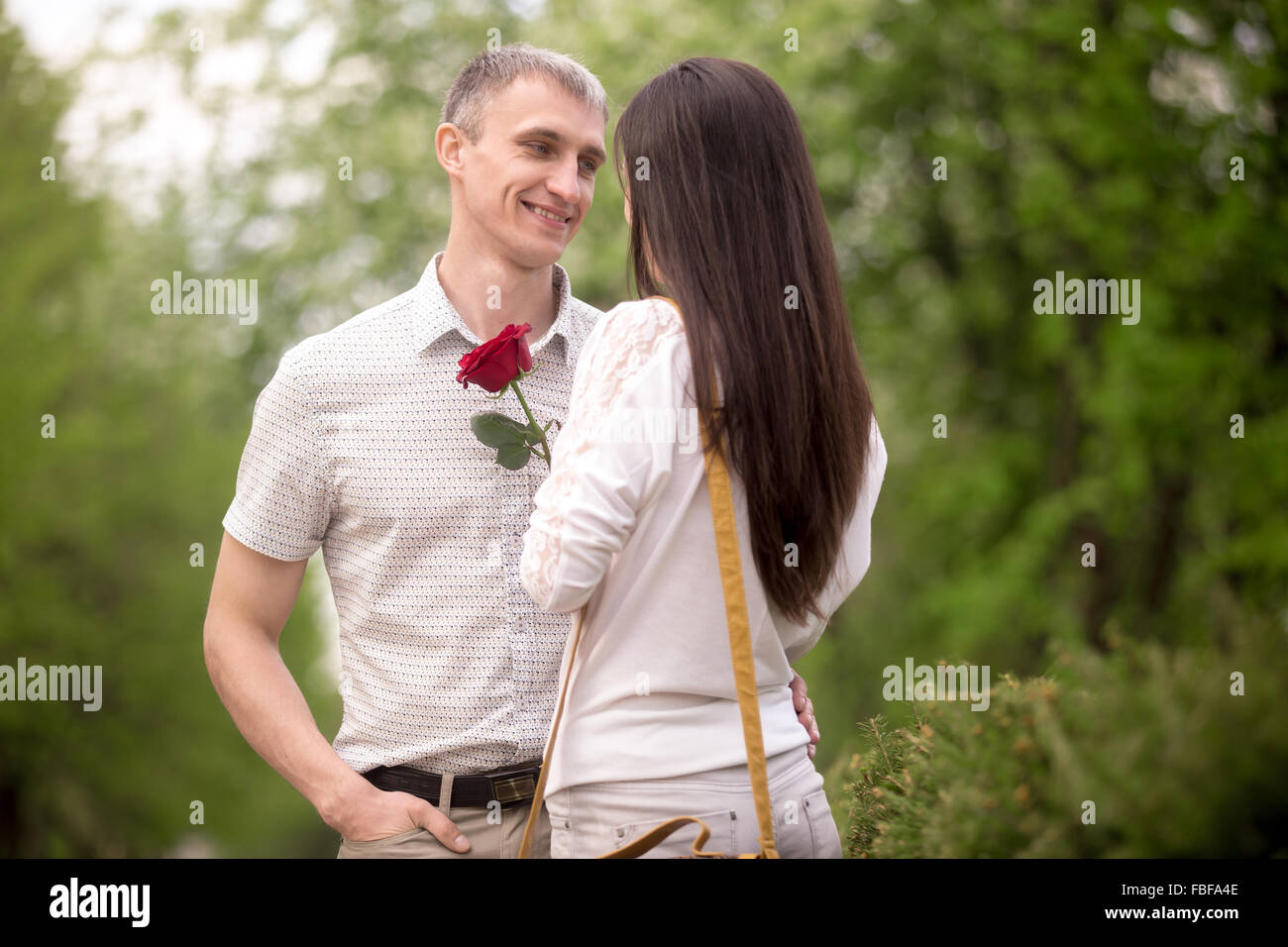Couple of lovers meeting on a date in park, looking each other in eyes ...