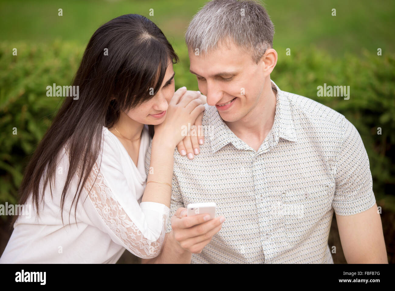 Young attractive happy smiling lovers couple in love sitting on park ...