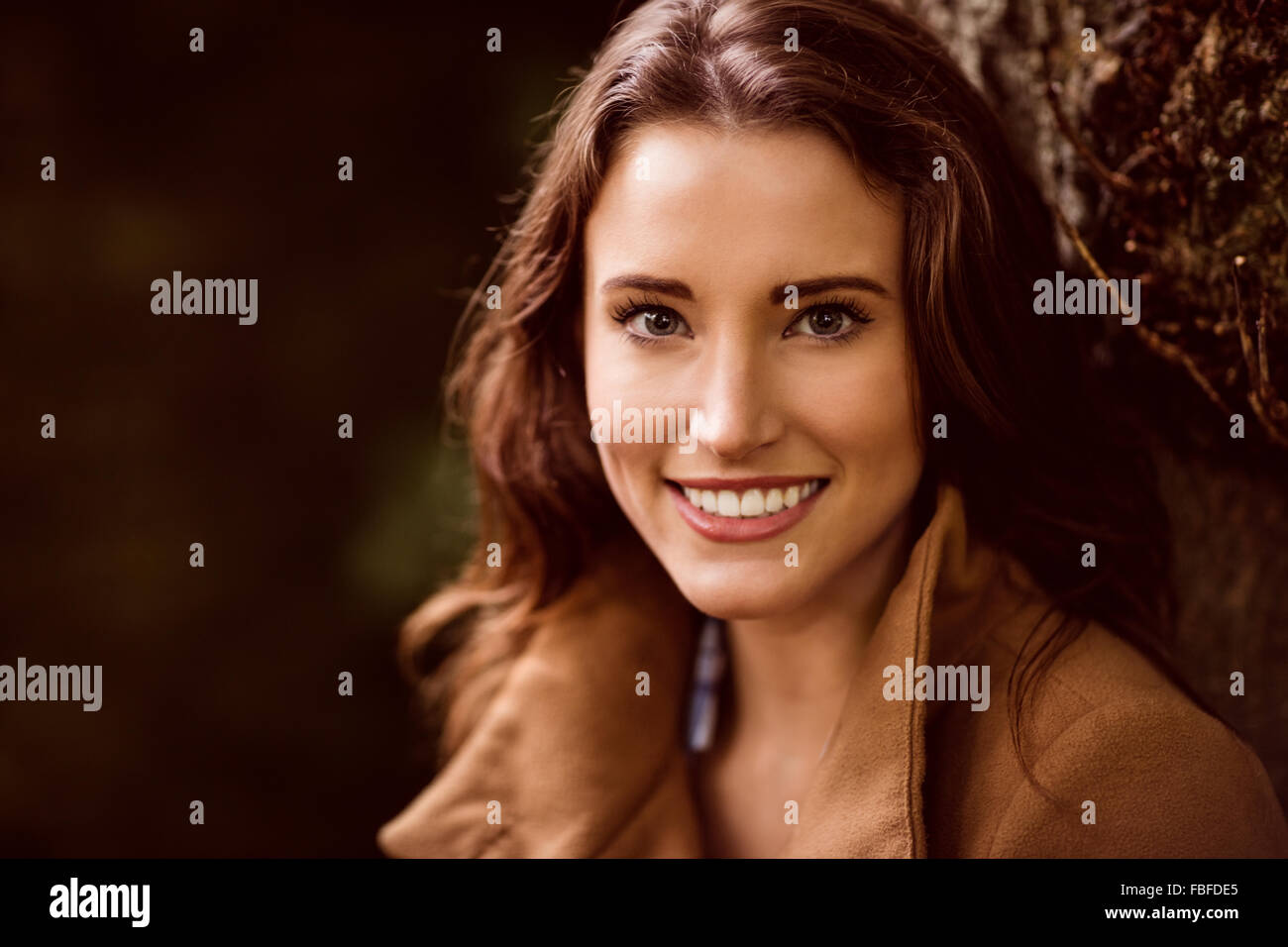 Woman posing next to a tree Stock Photo - Alamy