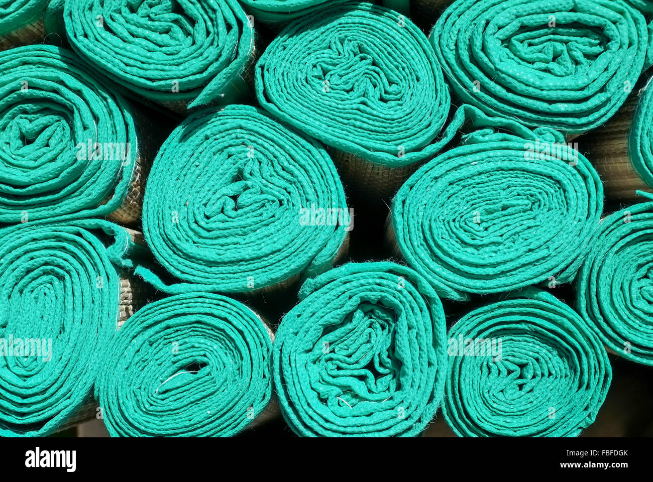 Colourful green rolled up beachmats on display at seaside resort Stock ...