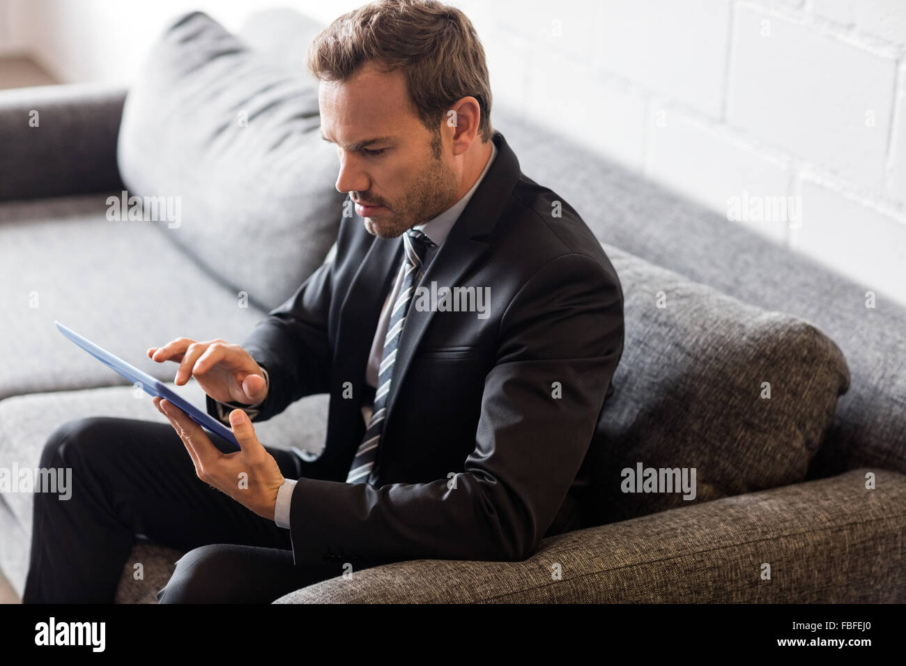 Focused businessman using tablet Stock Photo - Alamy