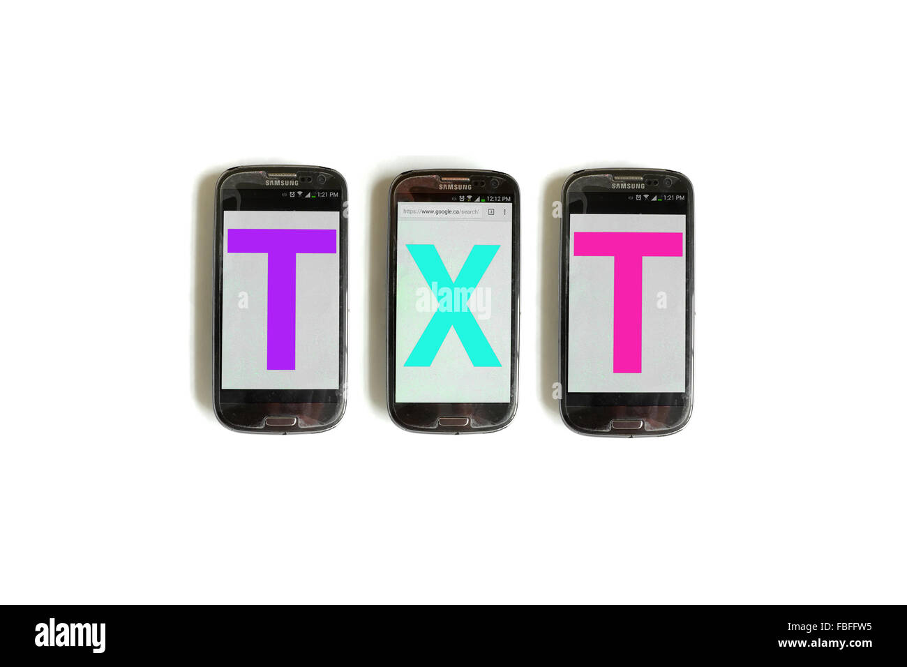 TXT written on the screens of smartphones photographed against a white ...
