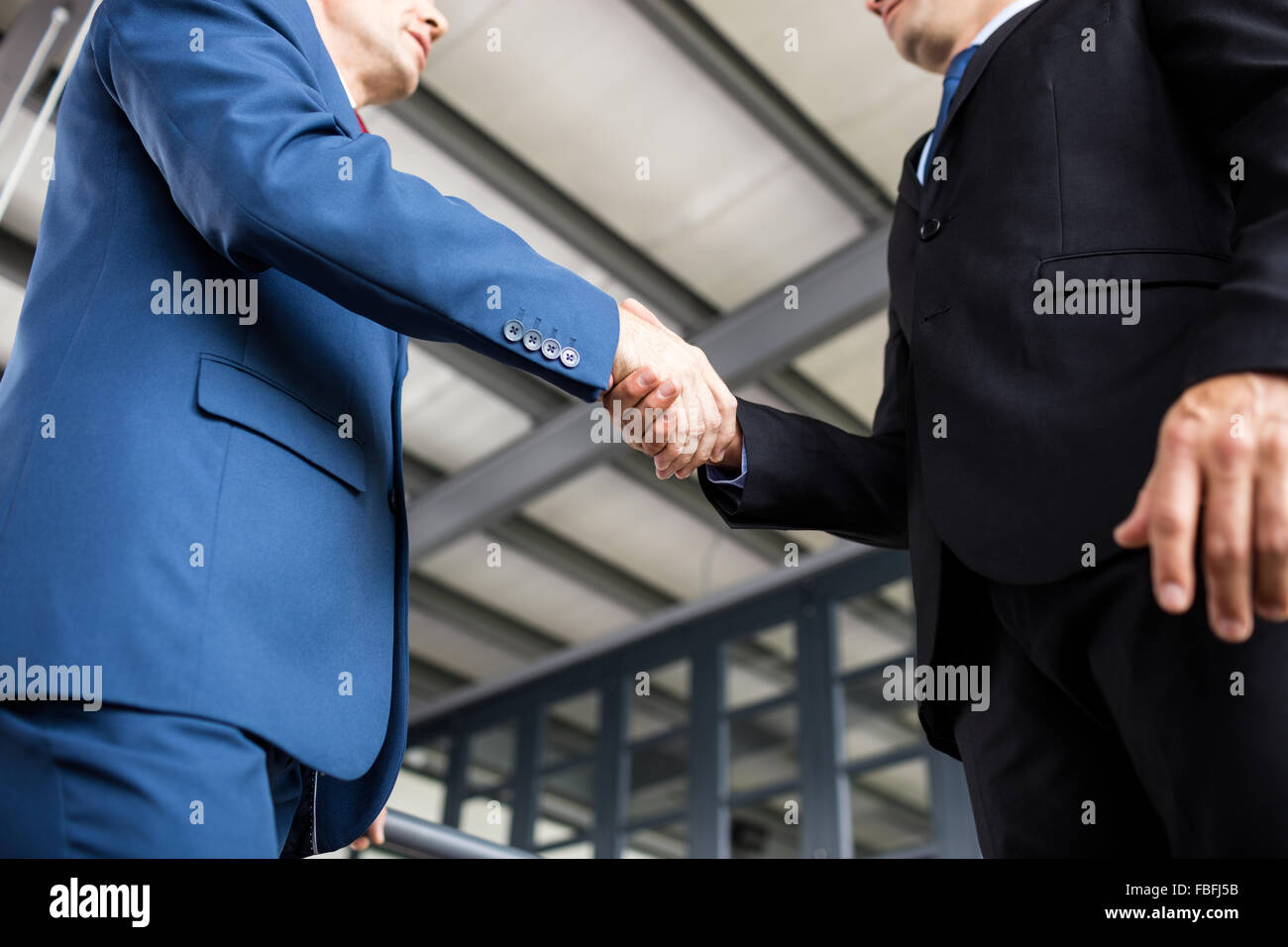 Two smiling businessmen shaking hands Stock Photo - Alamy
