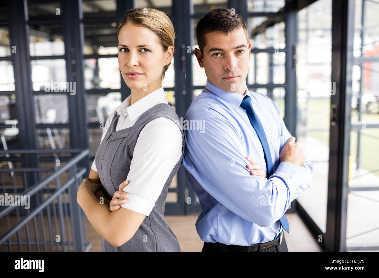 Business people standing back to back with arms crossed Stock Photo - Alamy