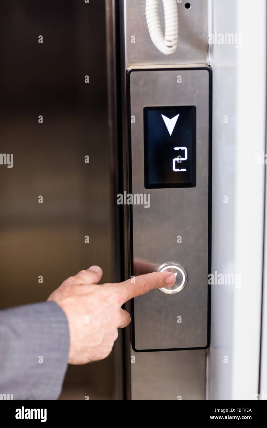 Close up view of businessman pressing elevators button Stock Photo - Alamy