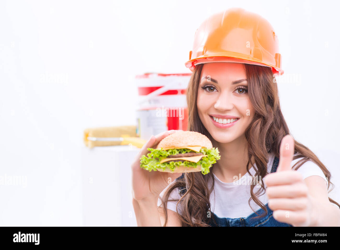 Girl is holding a burger and showing thumbs up Stock Photo - Alamy