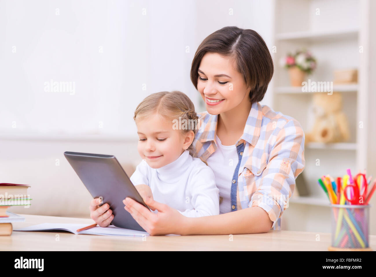 Mom and daughter are using portable tablet Stock Photo - Alamy