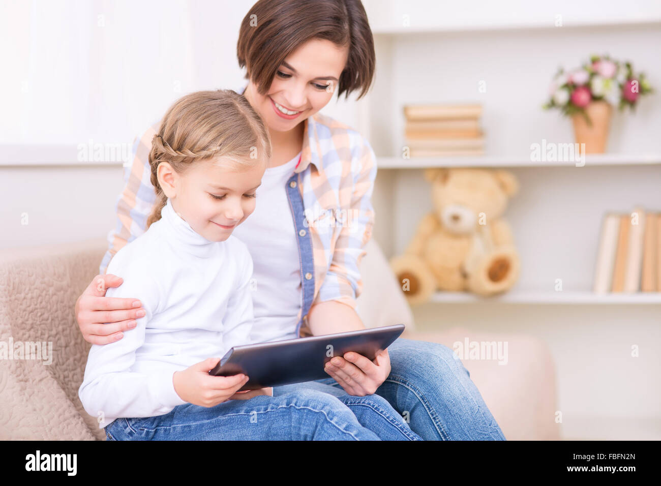 Little girl and her mom are using tablet Stock Photo - Alamy