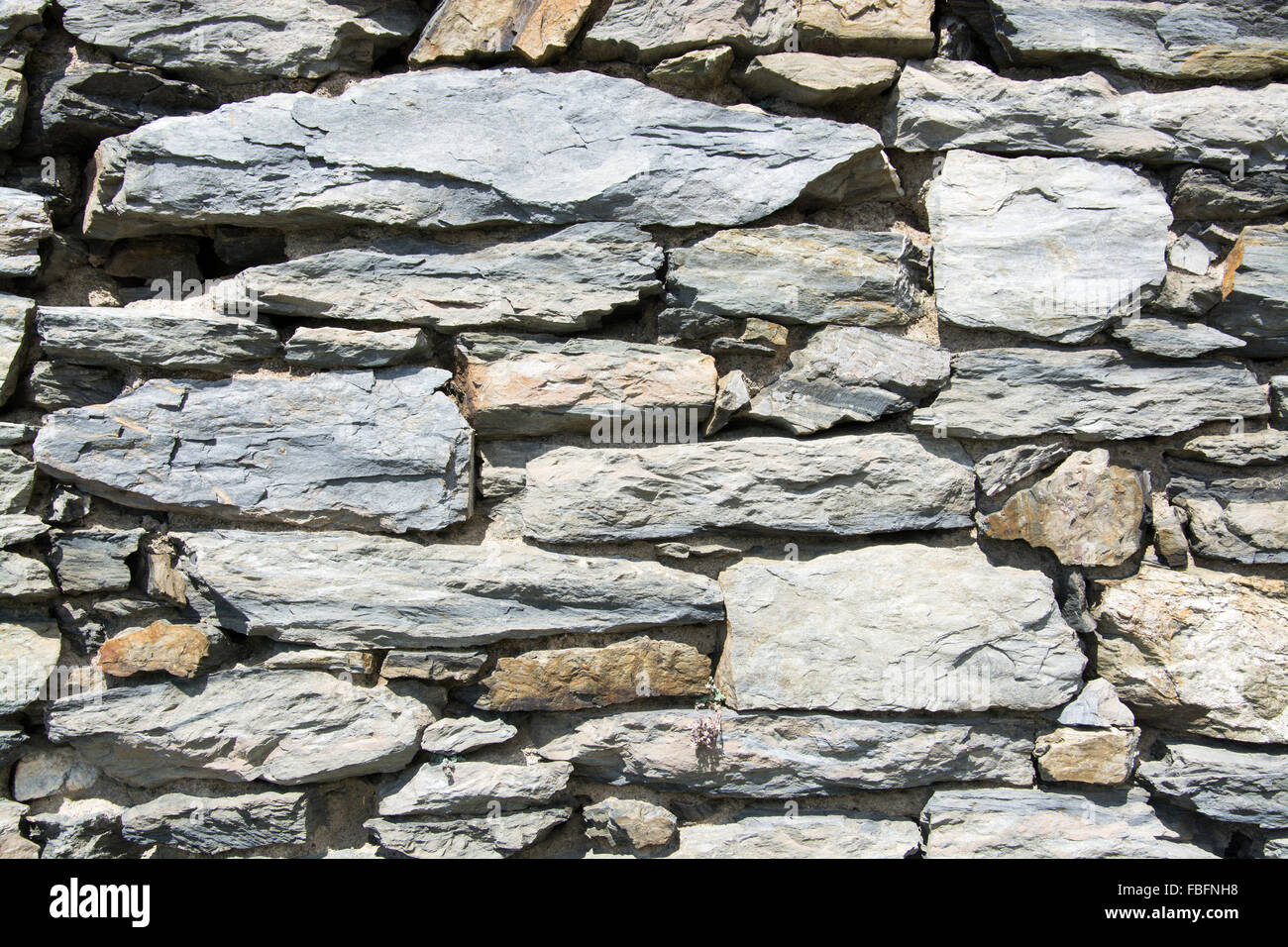 Wall build from natural stones Stock Photo - Alamy