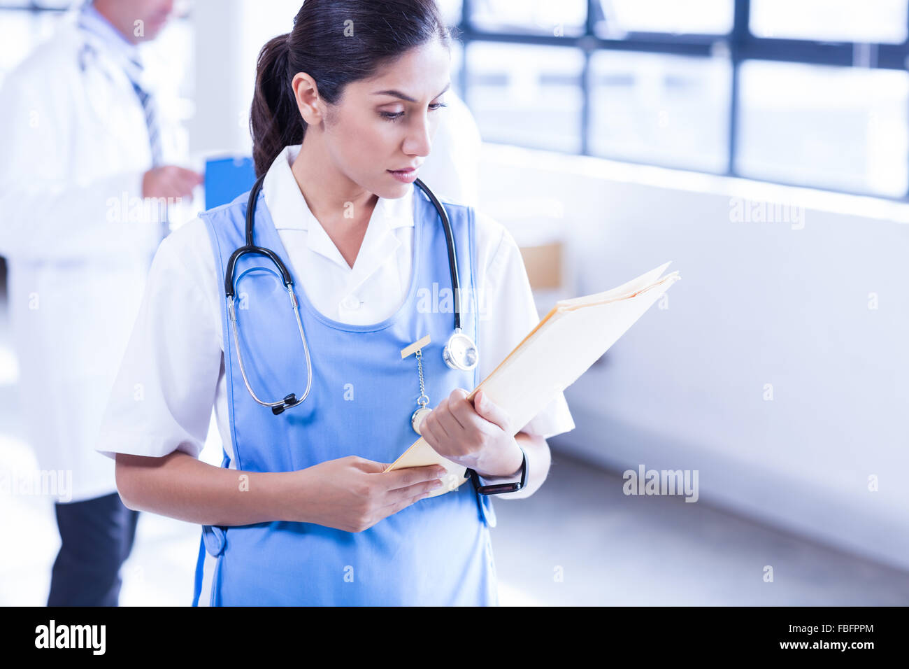 Nurse looking at medical files Stock Photo - Alamy