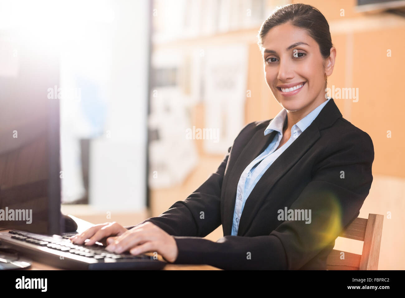 Smiling businesswoman typing on keyboard Stock Photo - Alamy