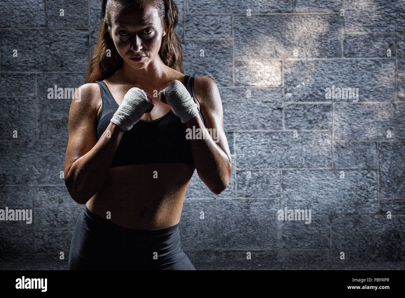 Composite image of portrait of female athlete with fighting stance ...