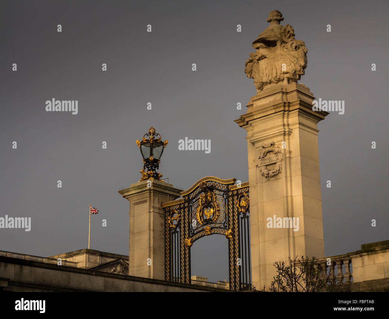 A stormy dark sky above buckingham palace gates and Union Jack flag ...