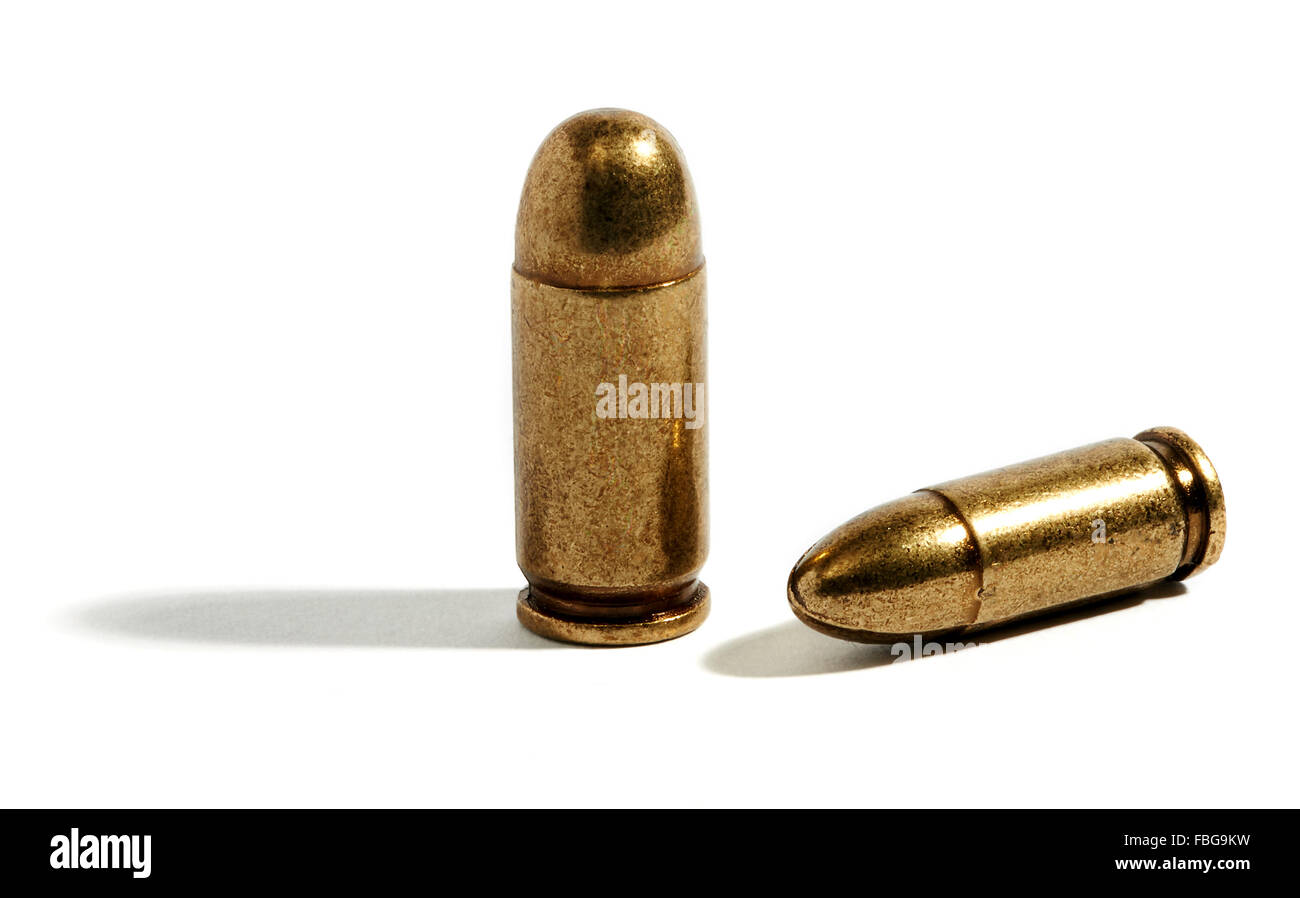 Two hollow point yellow bullets laying down and standing up over white ...