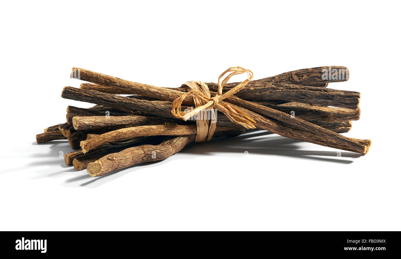 Single bundle of cut and dry licorice root tied with string over white ...