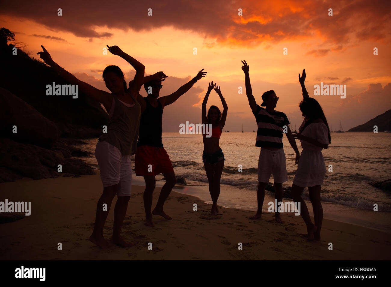 Group of people partying on beach at sunset Stock Photo - Alamy