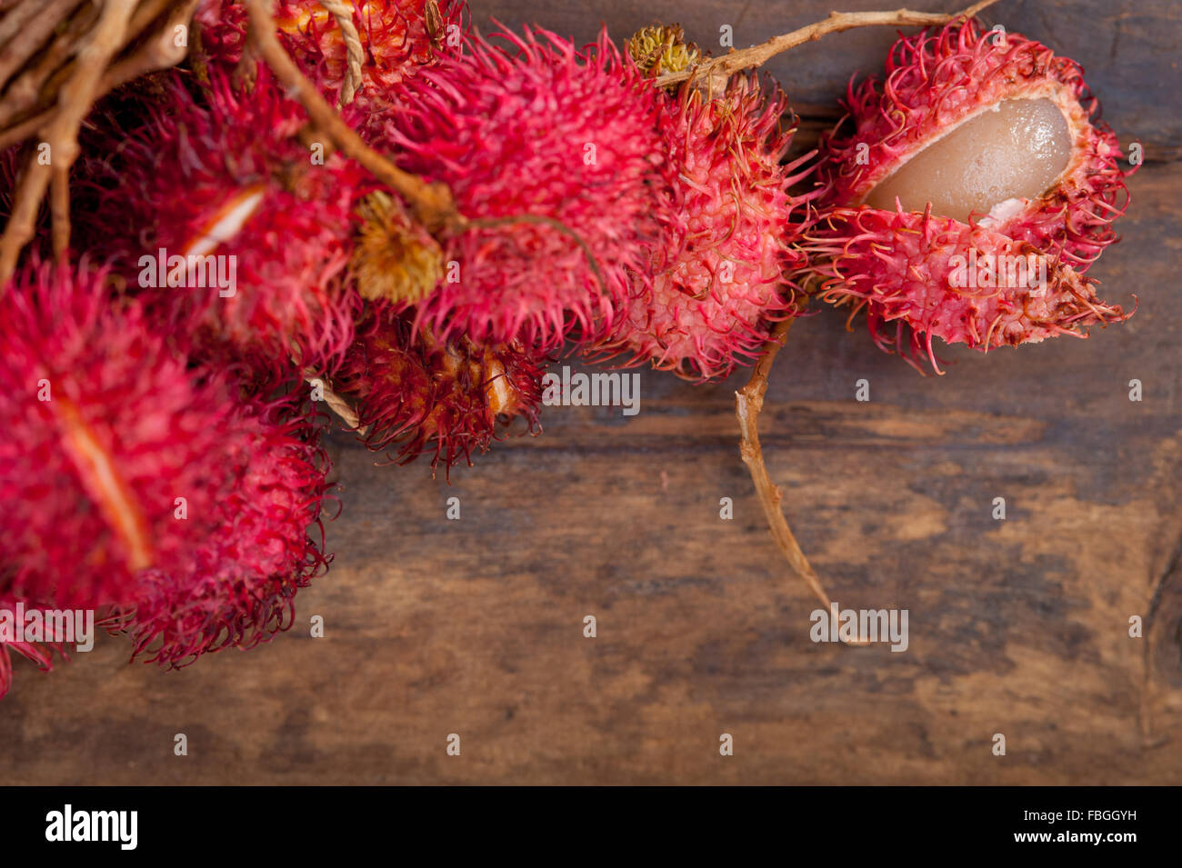 fresh tropical rambutan fruits over rustic wood table Stock Photo - Alamy