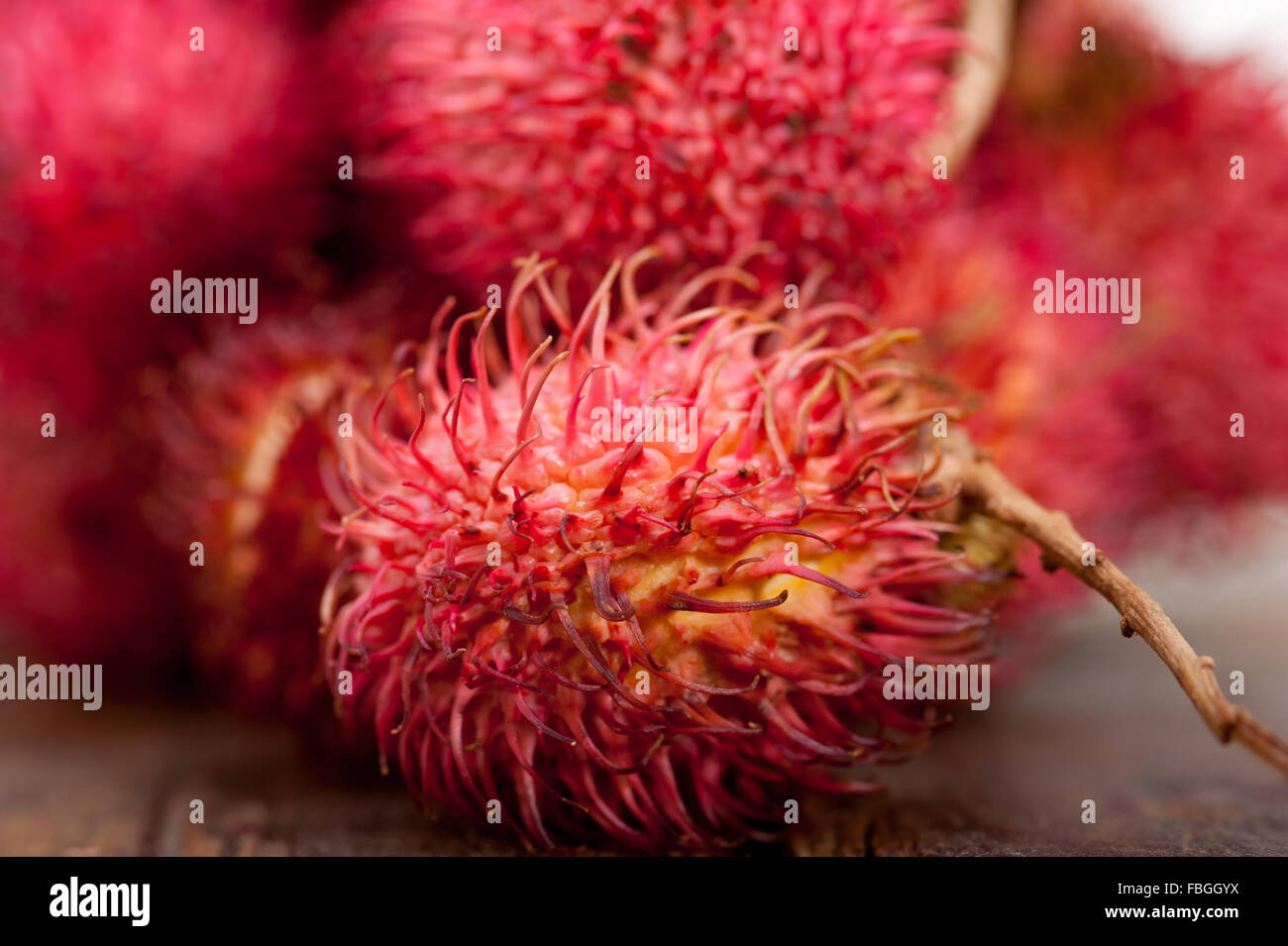 fresh tropical rambutan fruits over rustic wood table Stock Photo - Alamy