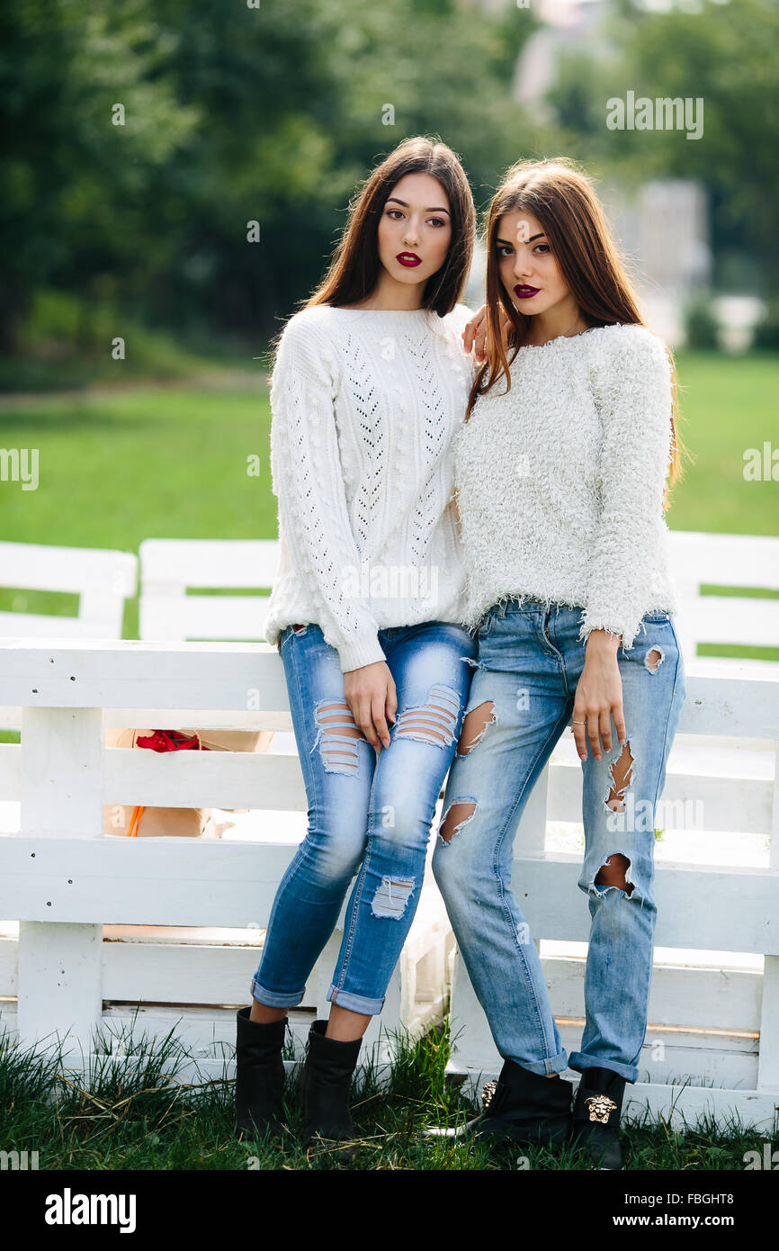 Two girls lean bench Stock Photo - Alamy