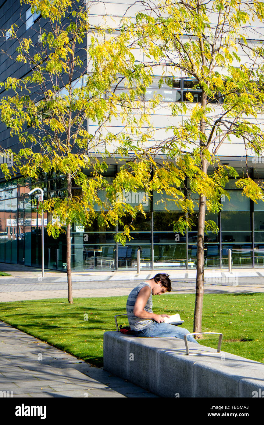 Student sitting on bench and reading outside Alan Turing building, The ...